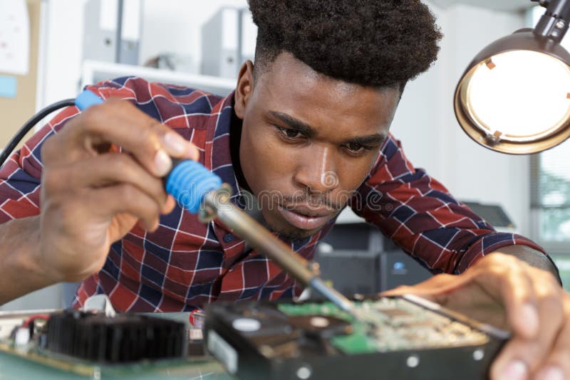 Concentrated Young Hardware Engineer in Glasses Soldering Pc Parts ...