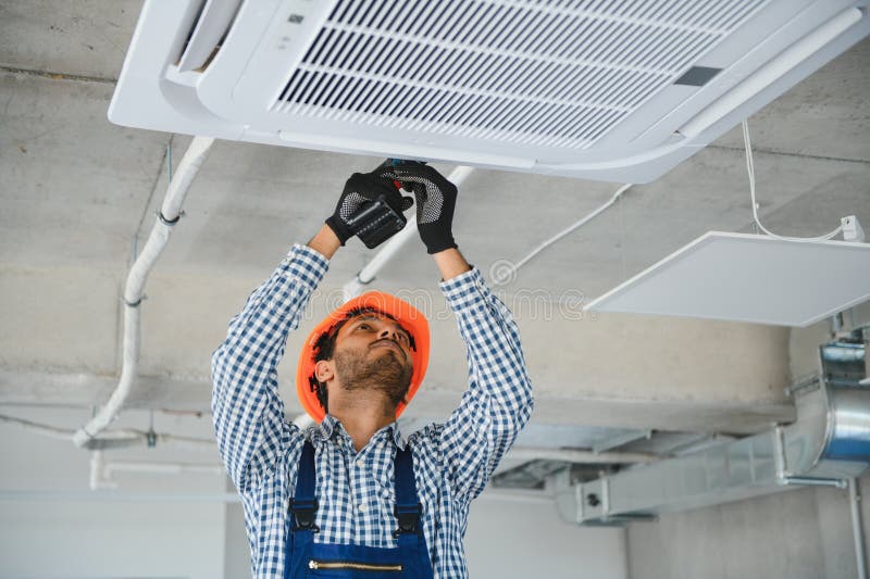 Concentrated Young Indian Engineer Setting Up Air Conditioner. Stock ...
