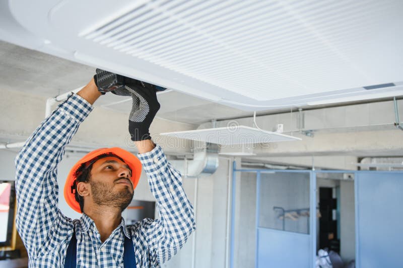 Concentrated Young Indian Engineer Setting Up Air Conditioner. Stock ...