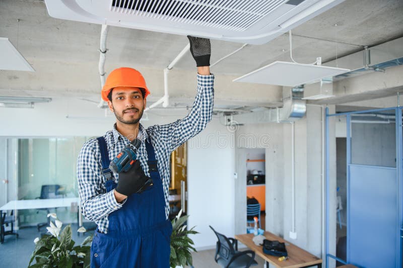 Concentrated Young Indian Engineer Setting Up Air Conditioner. Stock ...