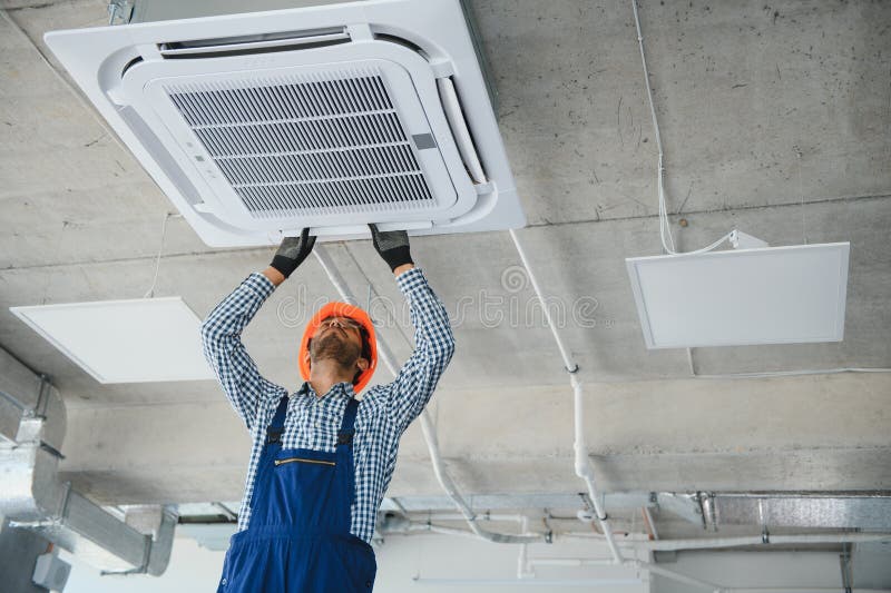 Concentrated Young Indian Engineer Setting Up Air Conditioner. Stock ...