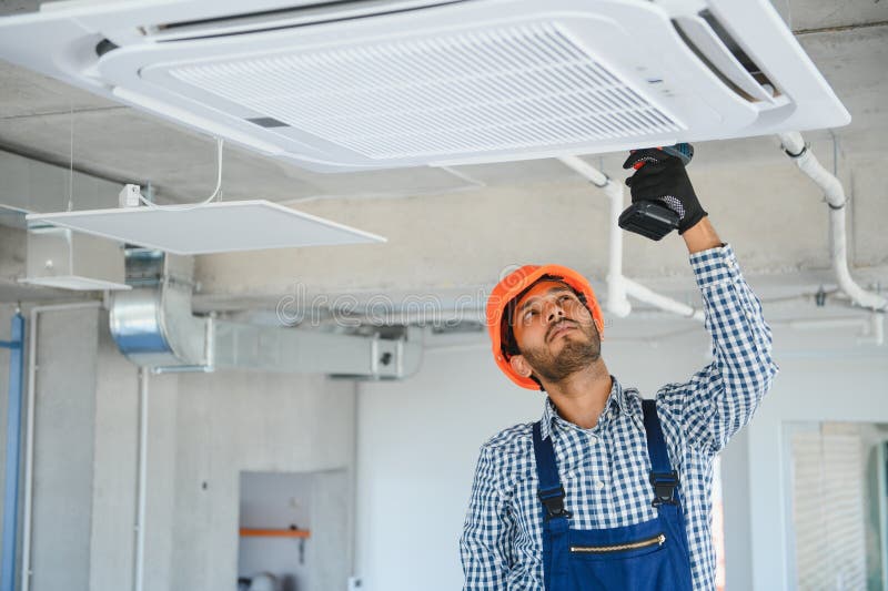 Concentrated Young Indian Engineer Setting Up Air Conditioner. Stock ...