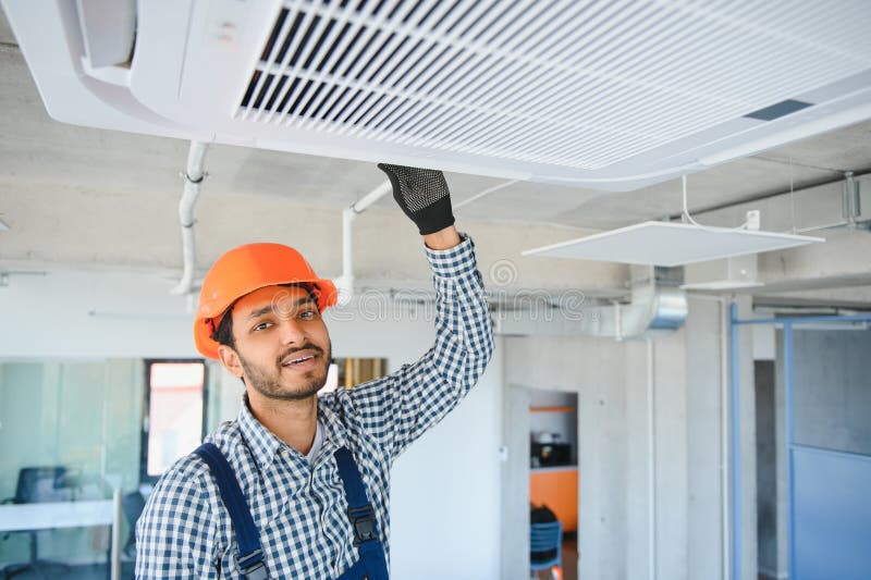 Concentrated Young Indian Engineer Setting Up Air Conditioner. Stock ...