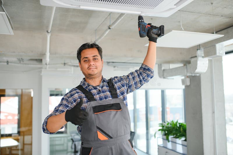 Concentrated Young Indian Engineer Setting Up Air Conditioner. Stock ...