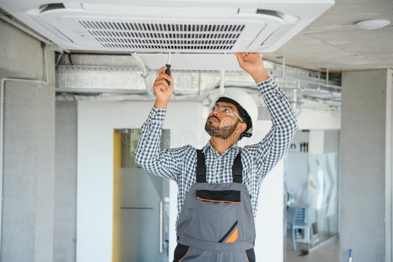 Concentrated Young Indian Engineer Setting Up Air Conditioner Stock ...