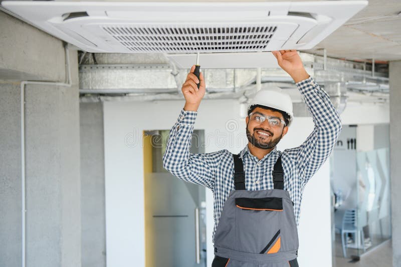 Concentrated Young Indian Engineer Setting Up Air Conditioner Stock ...