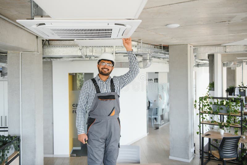 Concentrated Young Indian Engineer Setting Up Air Conditioner Stock ...