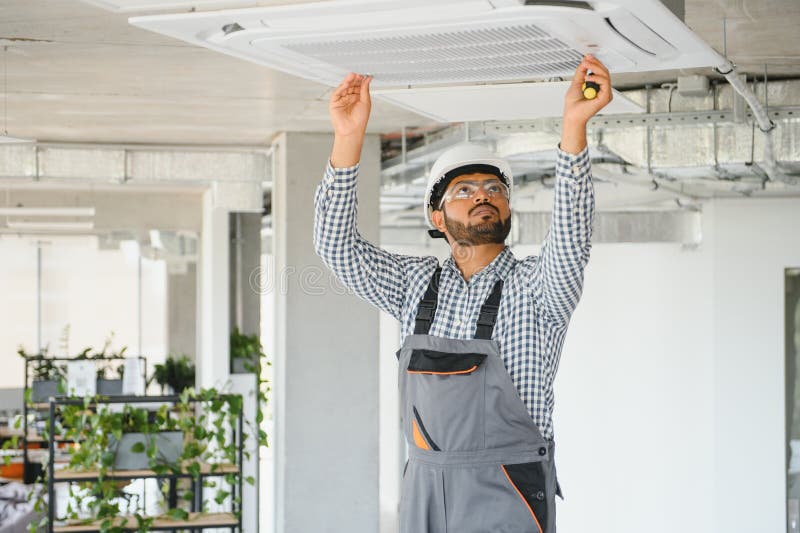 Concentrated Young Indian Engineer Setting Up Air Conditioner Stock ...