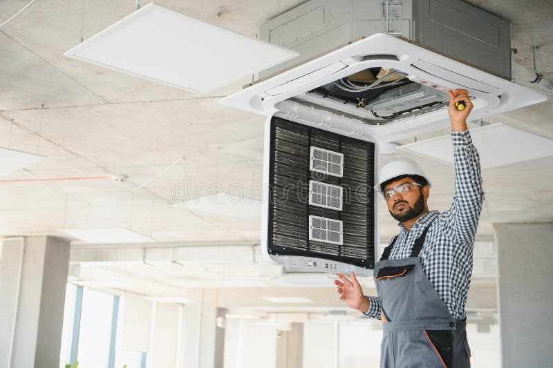 Concentrated Young Indian Engineer Setting Up Air Conditioner Stock ...