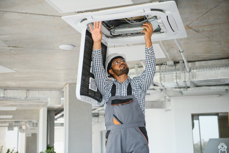 Concentrated Young Indian Engineer Setting Up Air Conditioner Stock ...
