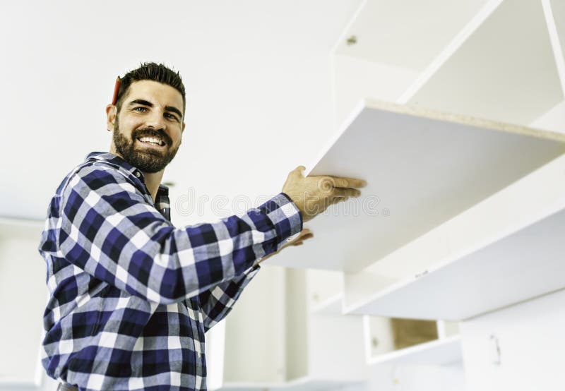 Concentrated Young Man Work with White Cabinet in the Kitchen Stock ...