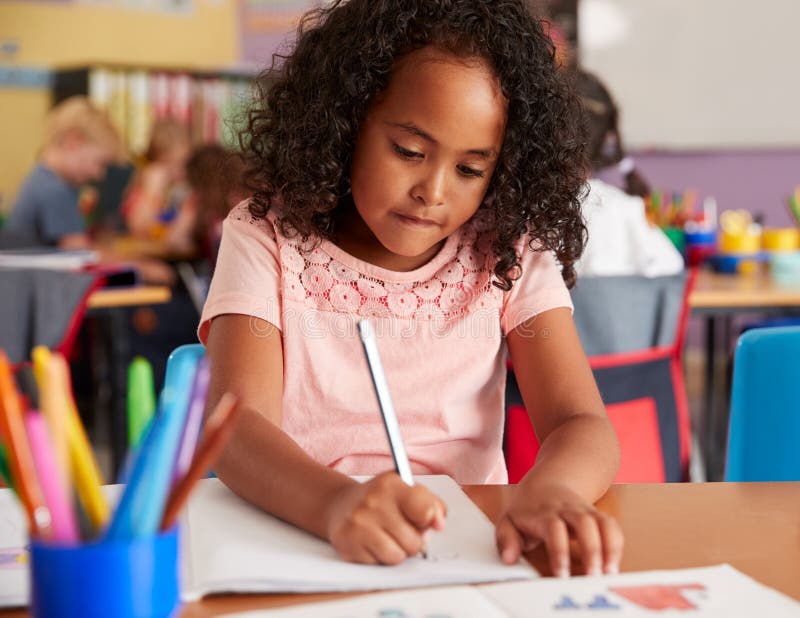 Concentrating Female Elementary School Pupils Working at Desk Stock ...