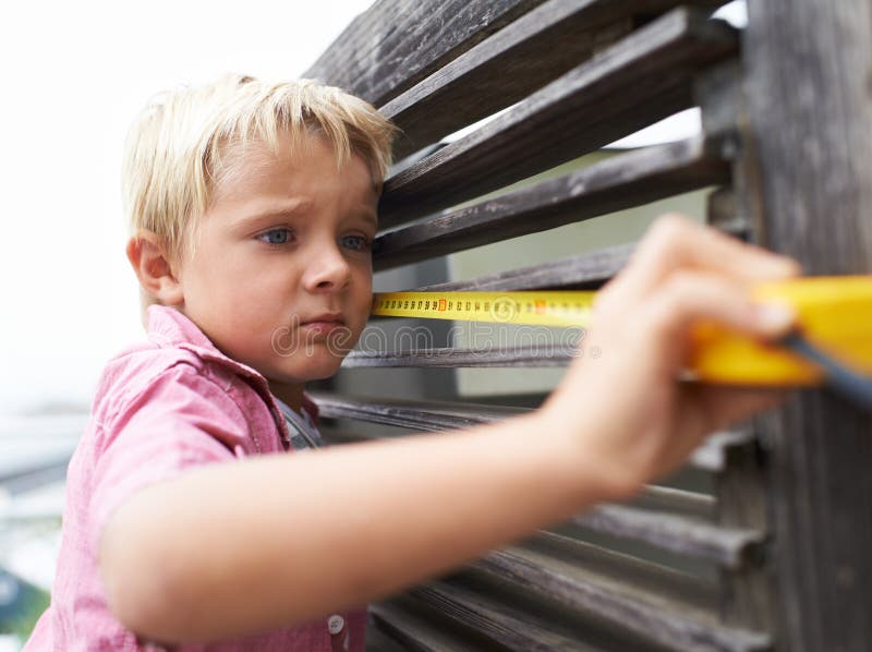 Concentrating on the Task Dad Gave Me. a Young Boy Measuring a Grill ...