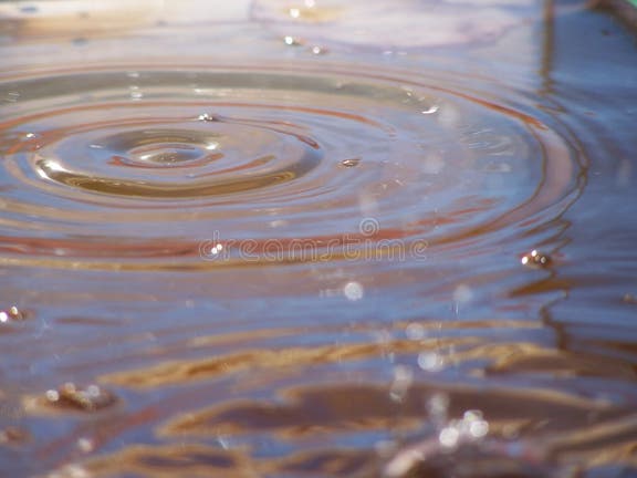 Concentric Waves Spread Out Creating Multihued Reflections after a Drop ...