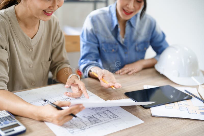 Concept of Engineering Consulting, Two Female Engineers Discussing about Blueprint of ...