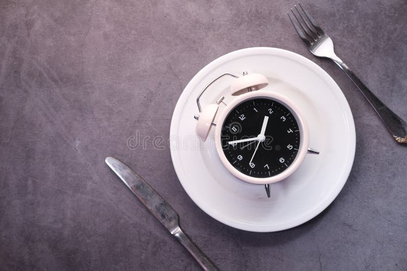 The Concept of Healthy Food, Alarm Clock on Plate Stock Photo - Image ... The Concept of Healthy Food, Alarm Clock on Plate Stock Photo - Image ...