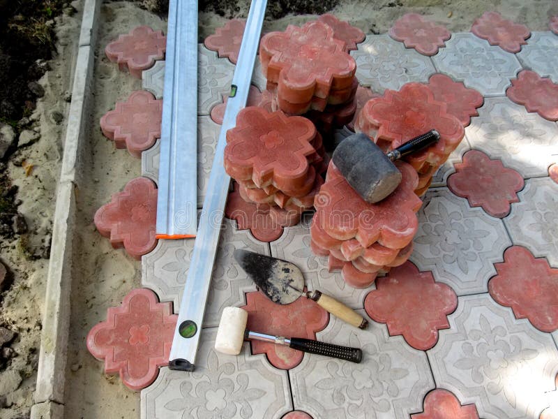 Tools For Laying Paving Tiles Close-up On A Background Of Red And White ...