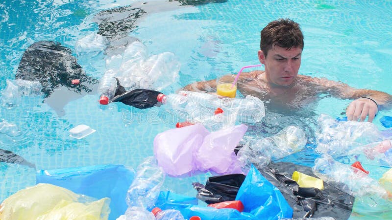 Concept of Pollution of the Planet. Young Shocked Man Swims among the ...