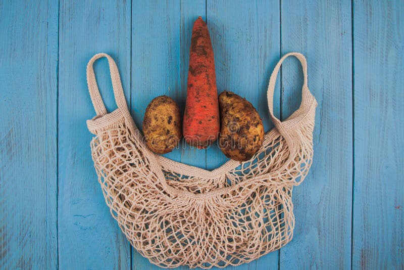 Carrot With Potatoes Arranged In The Shape Of A Penis On A Blue Board