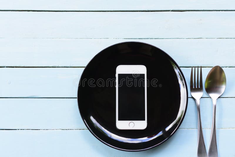 Concept Smartphone on Black Plate and Spoon with Fork on Blue ...