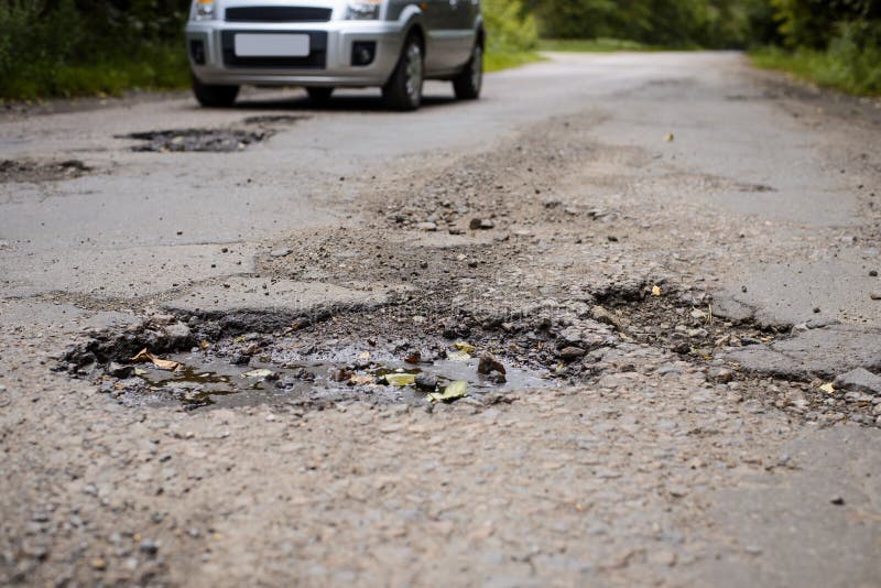 Damaged Asphalt Pavement Road with Many Big and Deep Potholes Stock ...