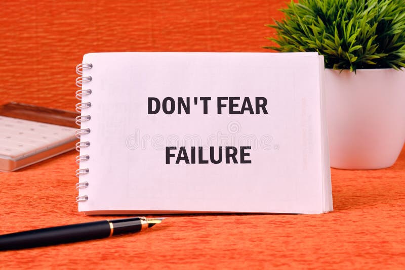 Concept Text DO NOT FEAR FAILURE on a Spiral Notebook on an Orange ...