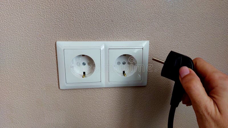 Concept of Unplugging or Plugging into Wall Electrical Socket Close ...