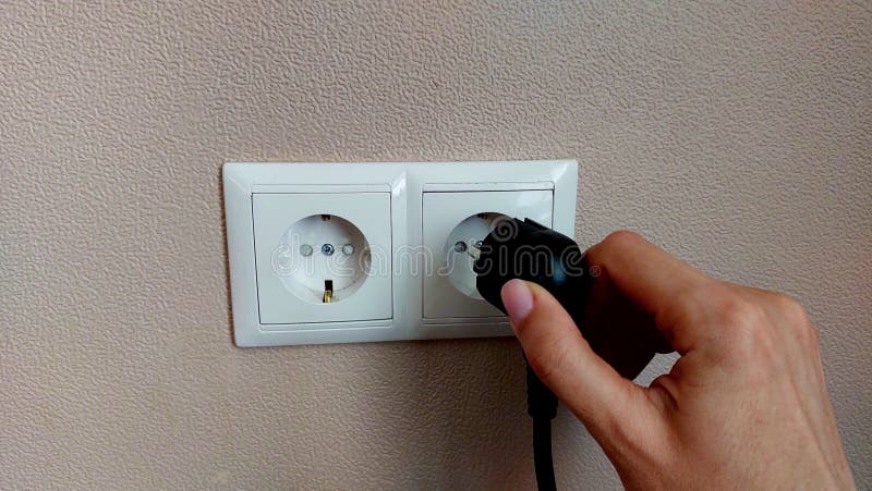 Concept of Unplugging or Plugging into Wall Electrical Socket Close ...