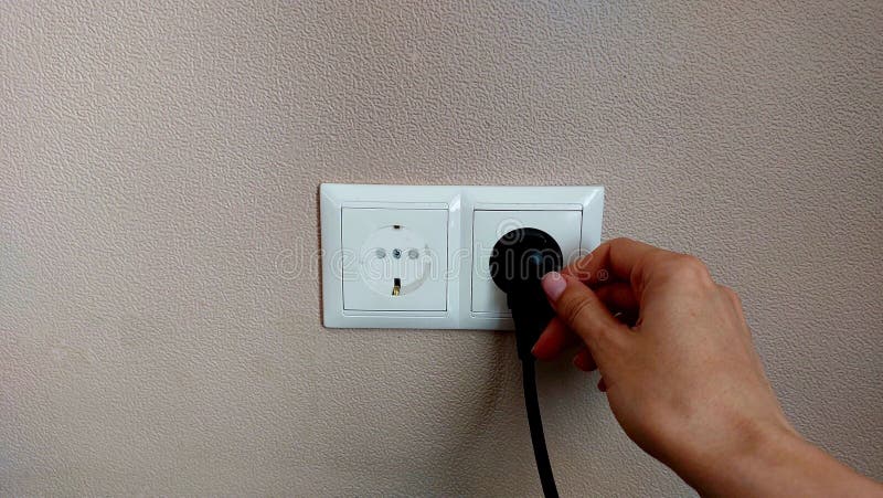 Concept of Unplugging or Plugging into Wall Electrical Socket Close ...