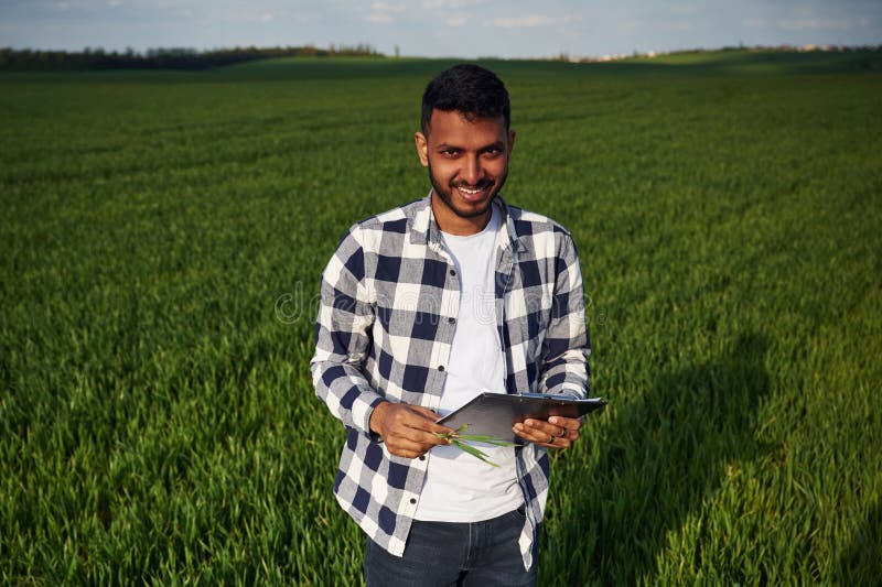 Standing and Holding Notepad. Handsome Indian Man is on the ...