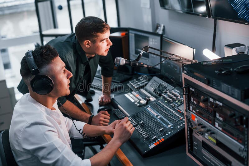 Conception of Teamwork. Two Guys is Indoors in the Radio Studio is Busy ...