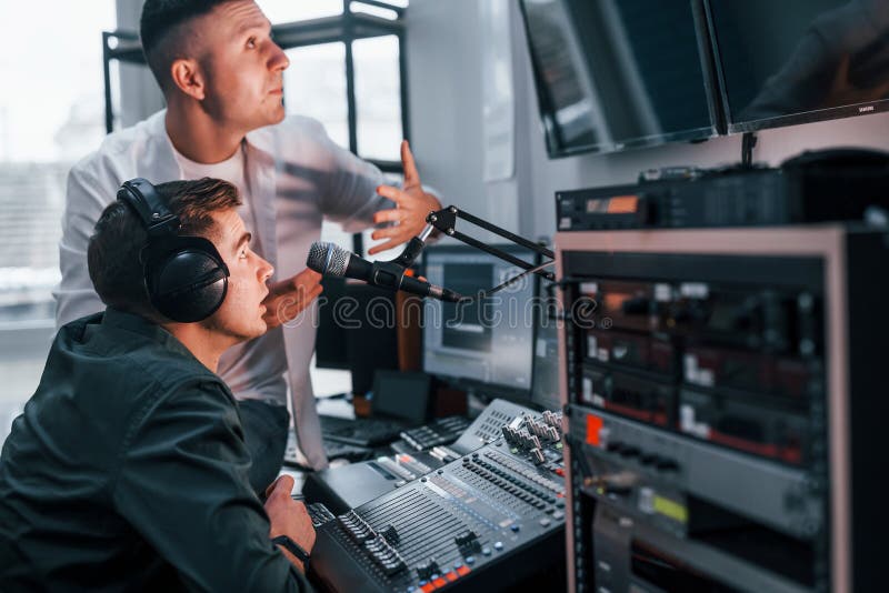 Conception of Teamwork. Two Guys is Indoors in the Radio Studio is Busy ...
