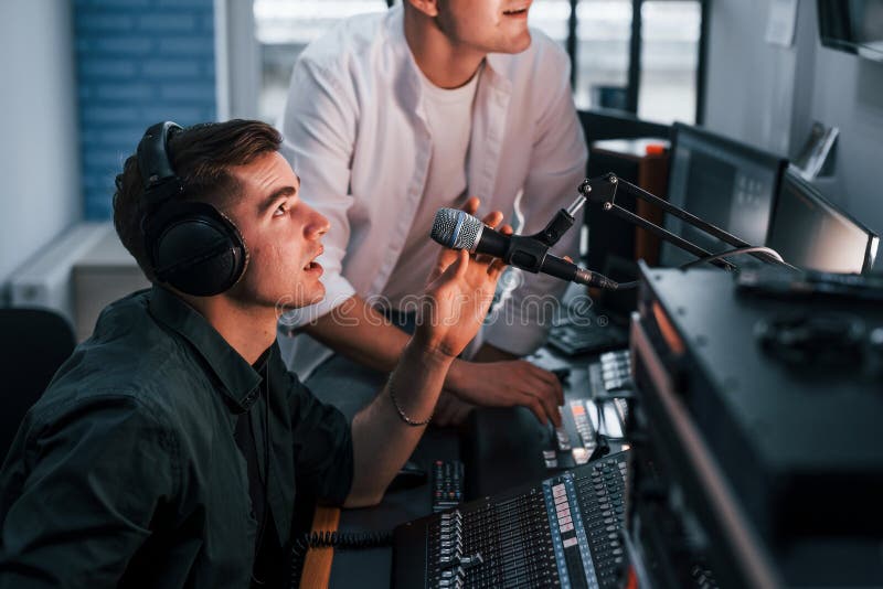 Conception of Teamwork. Two Guys is Indoors in the Radio Studio is Busy ...