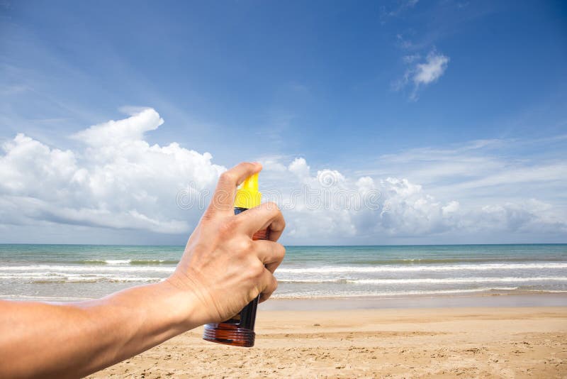 Hand Spraying Sunscreen Protection Oil with Beach and Blue Sky Stock ...