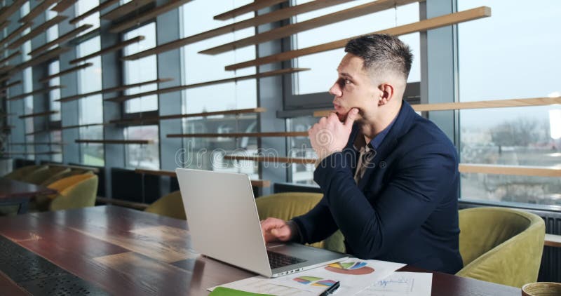 Concerned Man Working on Laptop Computer and Looking Away Thinking ...