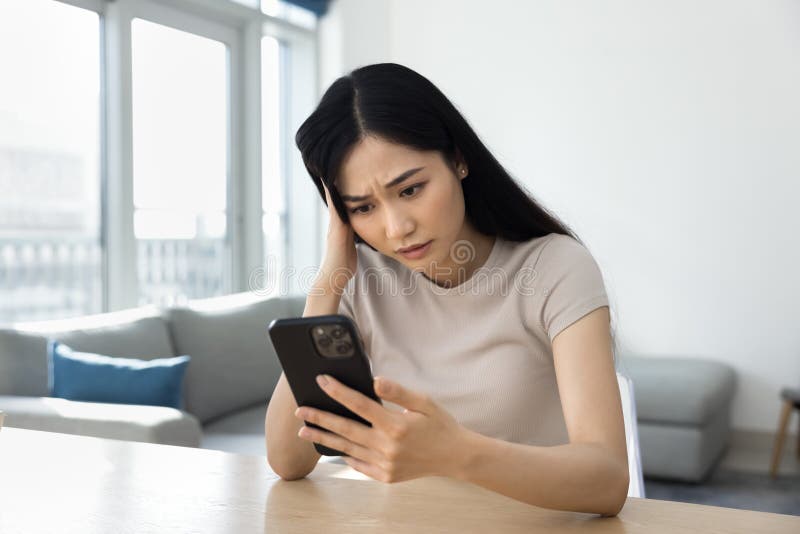 Concerned Young Asian Woman Using Smartphone at Home Table Stock Photo ...