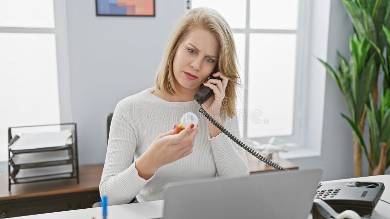 A Concerned Young Woman Examines Medication while Multitasking with a ...