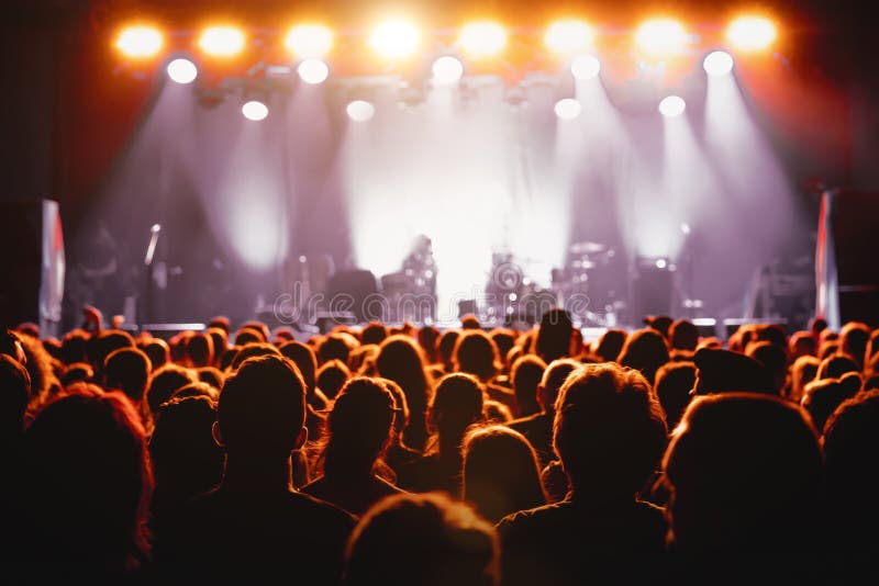 Concert Hall with a Lit Stage and People Silhouettes during a Concert ...