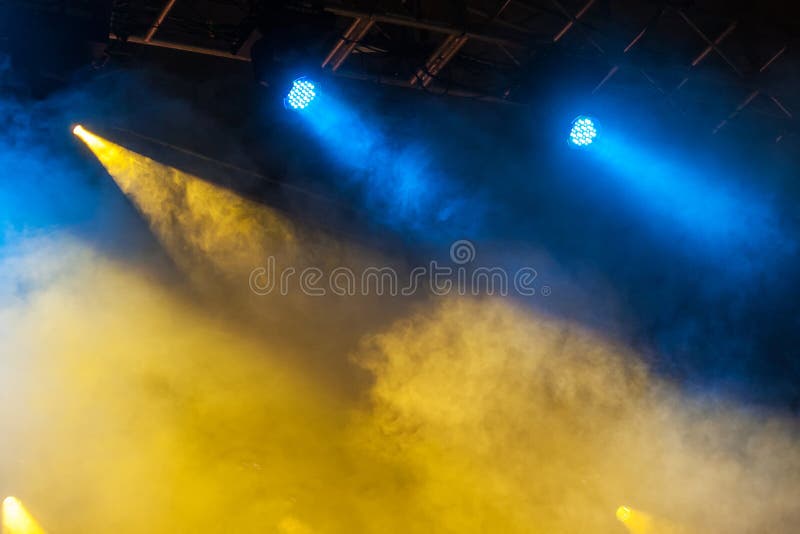 Blue Light Rays from the Spotlight through the Smoke at the Theater or ...