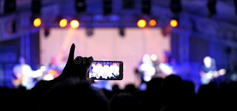 Concert Spectator Photographs the Band that Performs on Stage Stock ...