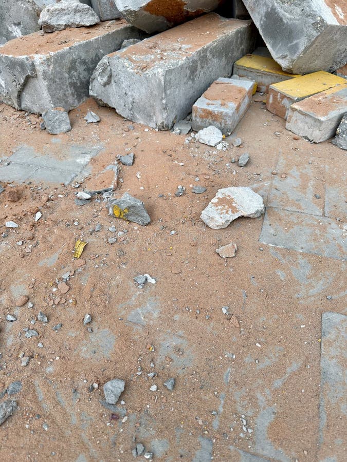 Concrete Blocks and Bricks are Scattered Over a Sandy Surface ...