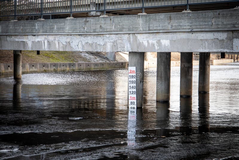 Concrete Bridge with Depth Marker Reflected in the Water Below Stock ...