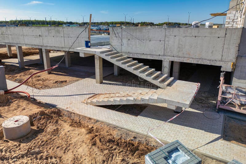 A Concrete Building is Under Construction, with Workers Busy Assembling ...