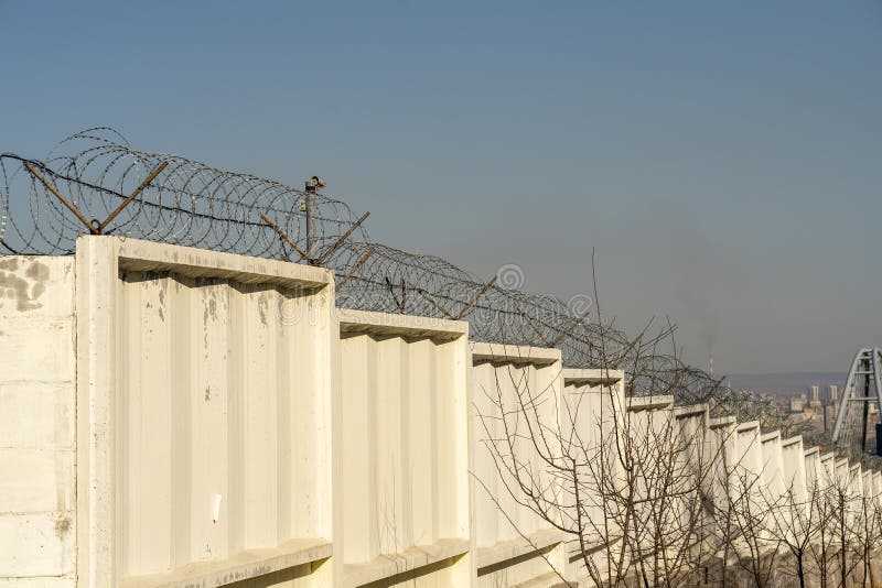 Concrete Fence with Barbed Wire on Top. Stock Photo - Image of ...