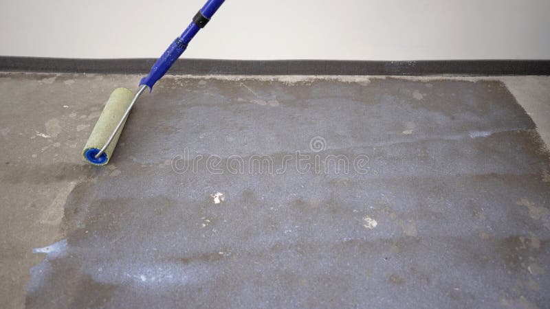 Concrete Floor Primer. the Process of Applying a Primer with a Roller ...