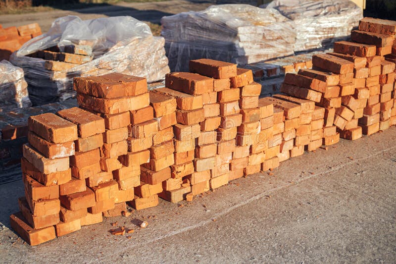 Concrete Foundation with Bricks for Laying. Stack of Red Bricks on ...