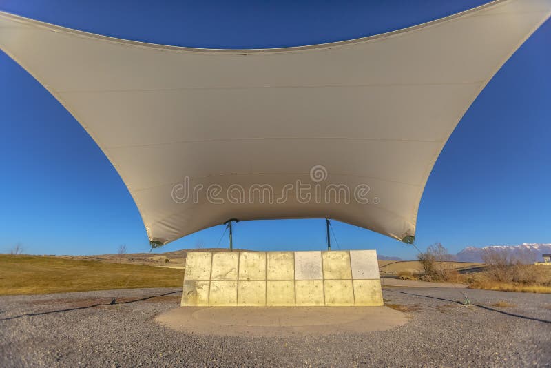 Concrete Rectangular Structure Under a White Canopy Against Vivid Blue ...