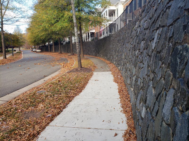 Concrete Sidewalk Along Decorative Stone Wall. Alley Along the Road ...