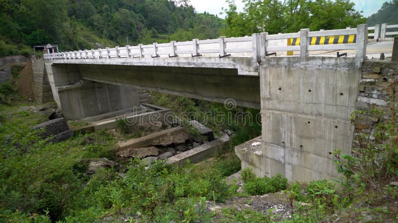 A Concrete Solid Slab Bridge Connecting Two Small Hills at the Base in ...