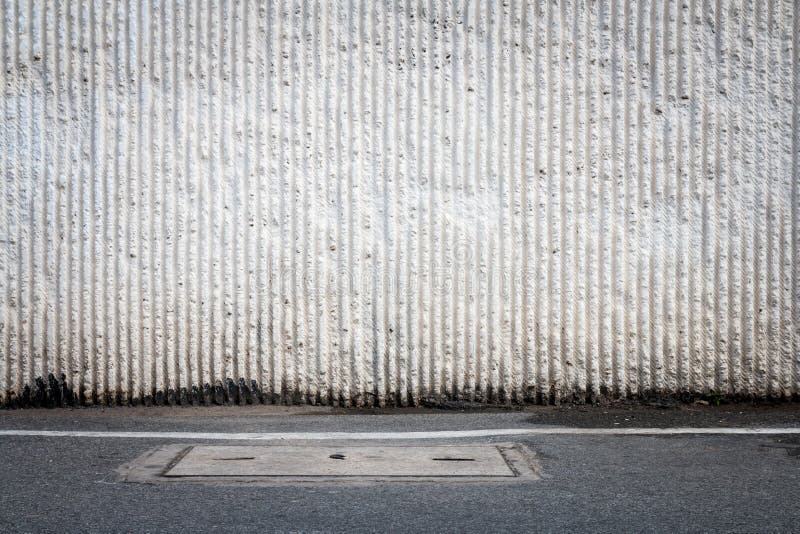 Concrete Wall and Asphaltic Road Stock Image - Image of manhole, street ...